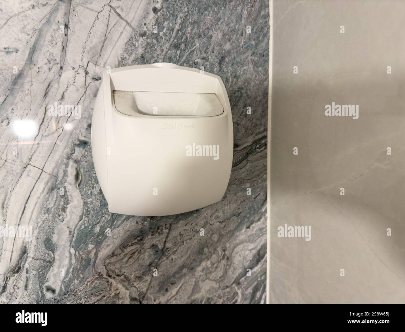 Wall-mounted hand sanitizer dispenser in a modern restroom setting ...