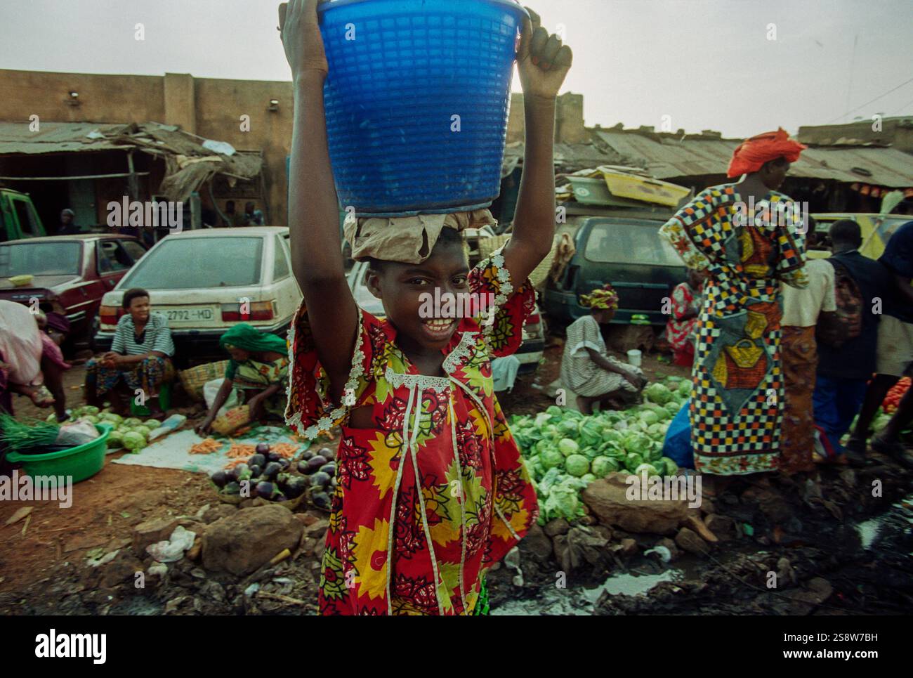 Women carrying provisions in the slums of Bamako scattered throughout ...