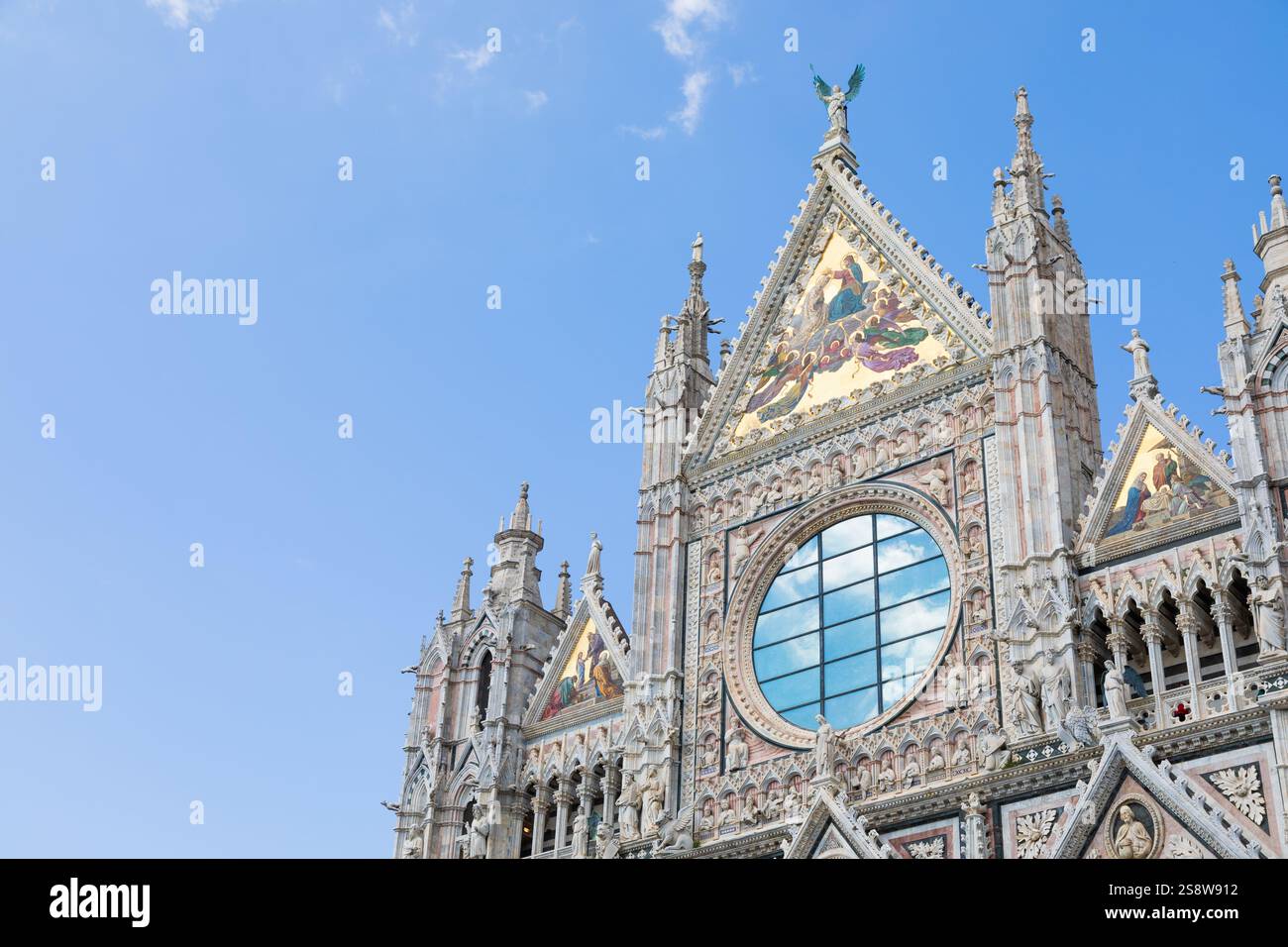 Siena cathedral in Italy. White marbles with blue sky, famous landmark ...