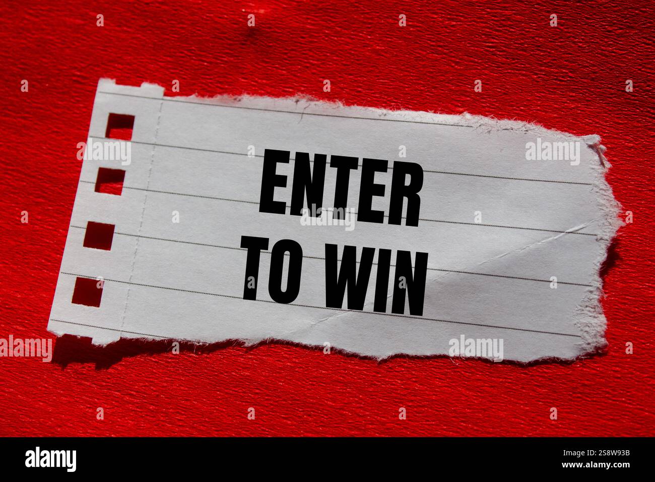 Enter to win message written on ripped torn paper piece with red ...