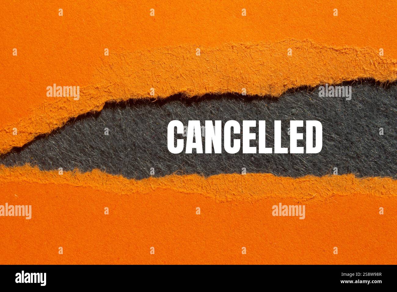 Cancelled message written on ripped torn orange paper with gray background. Conceptual cancelled ...