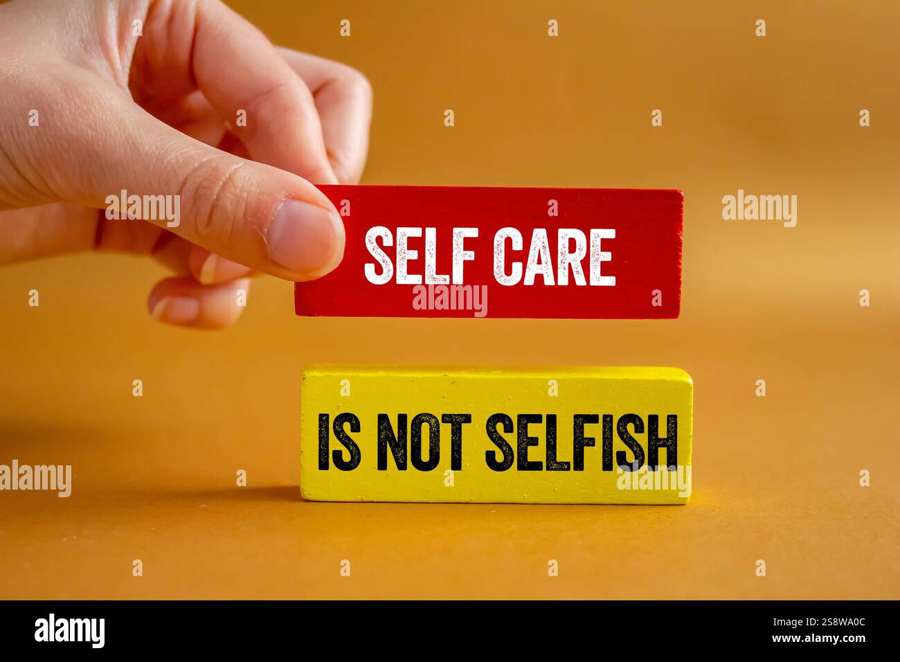 Self care is not selfish message written on wooden blocks on brown background. Conceptual self ...
