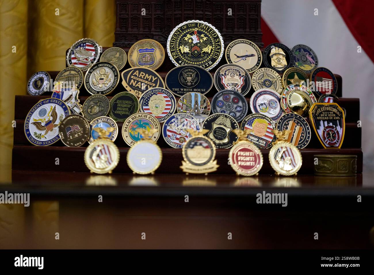 A collection of challenge coins is displays on a table behind President ...