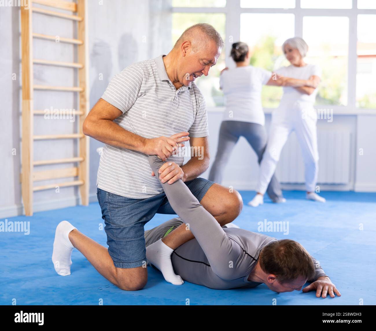 Self defense lesson - elderly man twists the arm of attacking man with ...