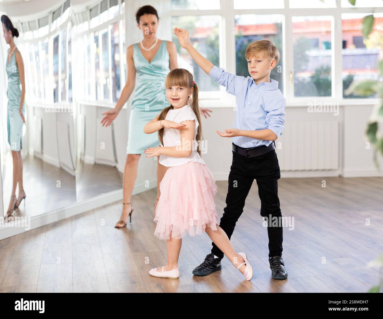 Tween girl and boy rehearsing rumba as couple in dance studio Stock Photo - Alamy