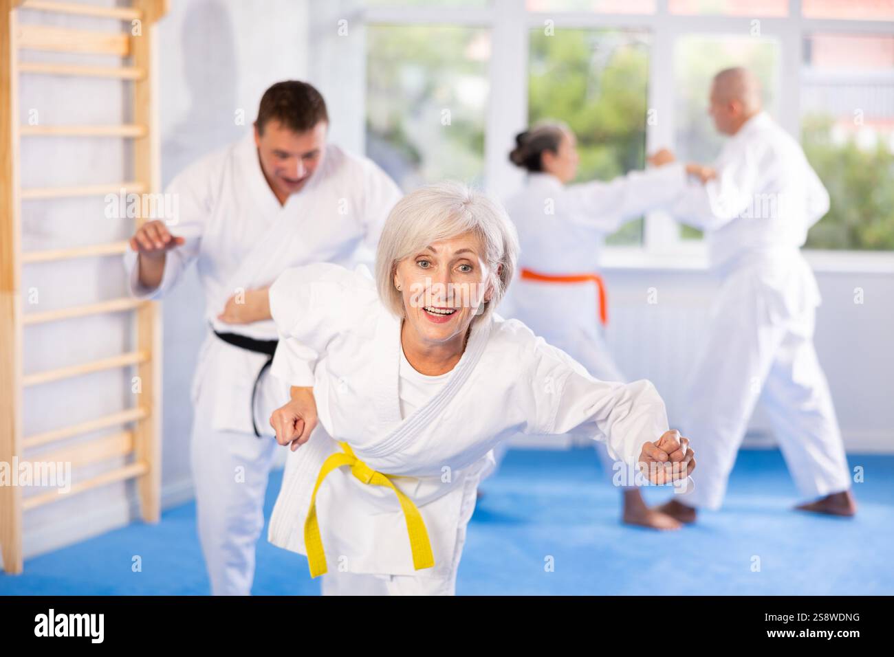 Old woman attendee of karate classes fighting with her opponent in ...