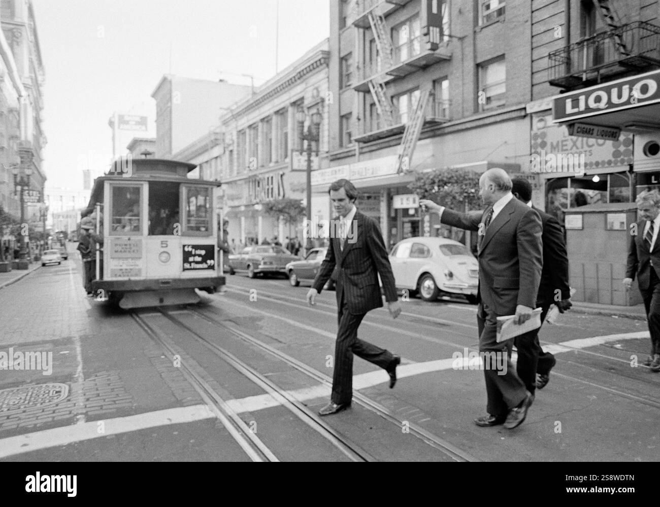 San Francisco mayor Joseph Alioto waves to a cable car as he walks to ...