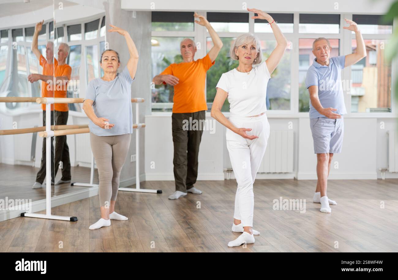 Energetic elderly woman ballet dancer executing ballet movements with ...