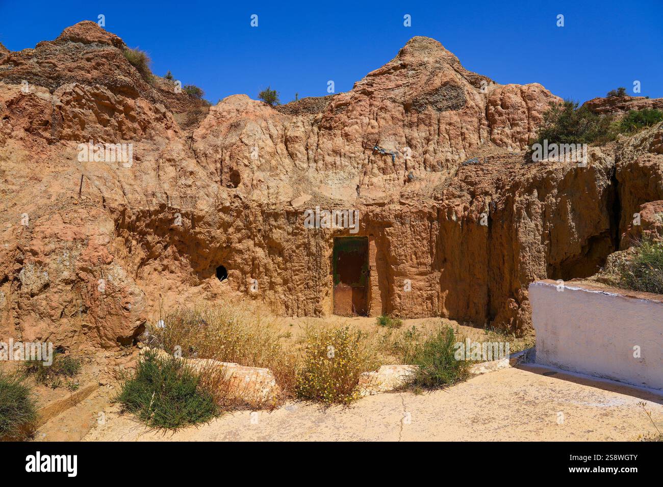 Door on the rocky face of a mountain, leading to a troglodyte cave ...