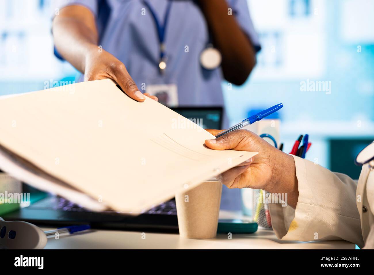 Female nurse brings the patient clinical records for a checkup routine ...