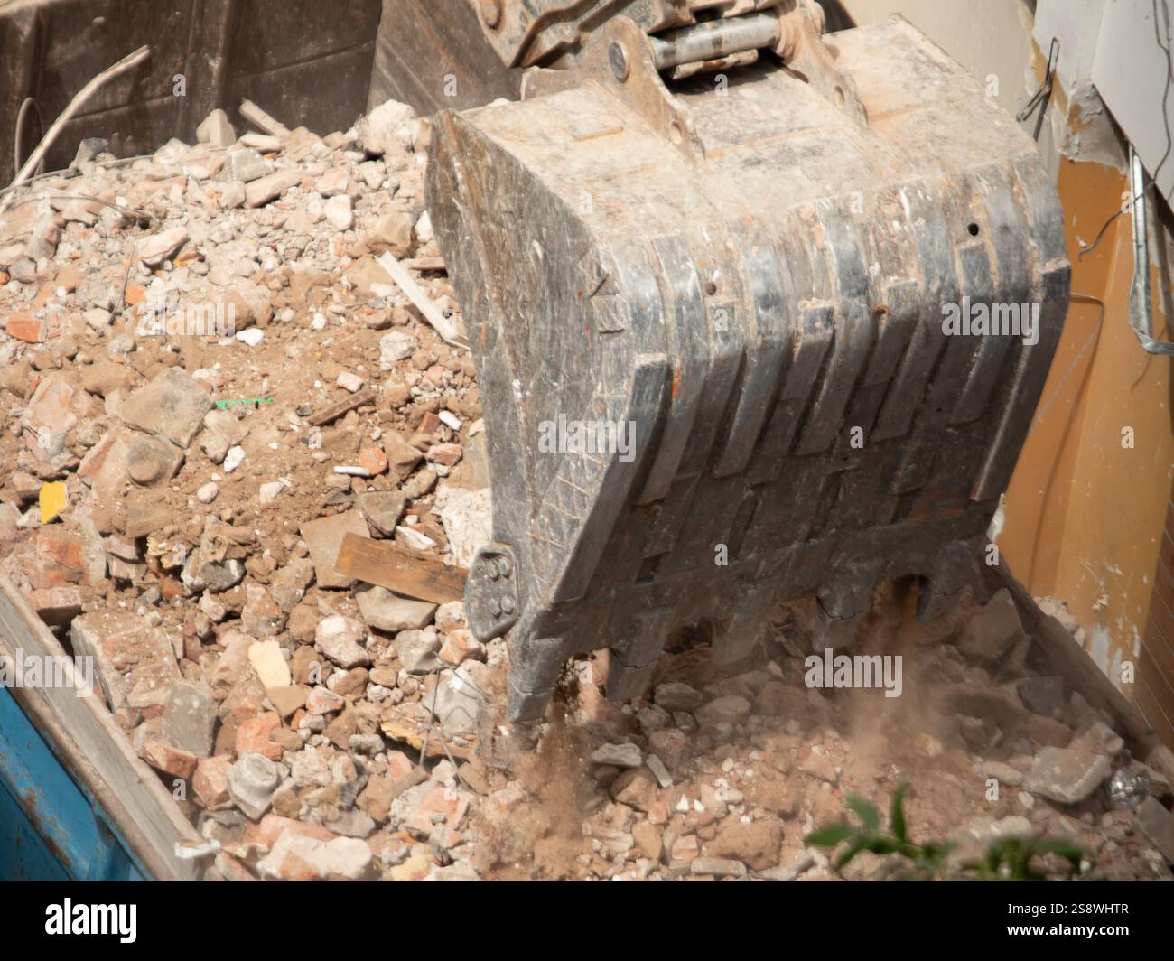 Excavator removing debris from a demolition site and dumping it Stock ...