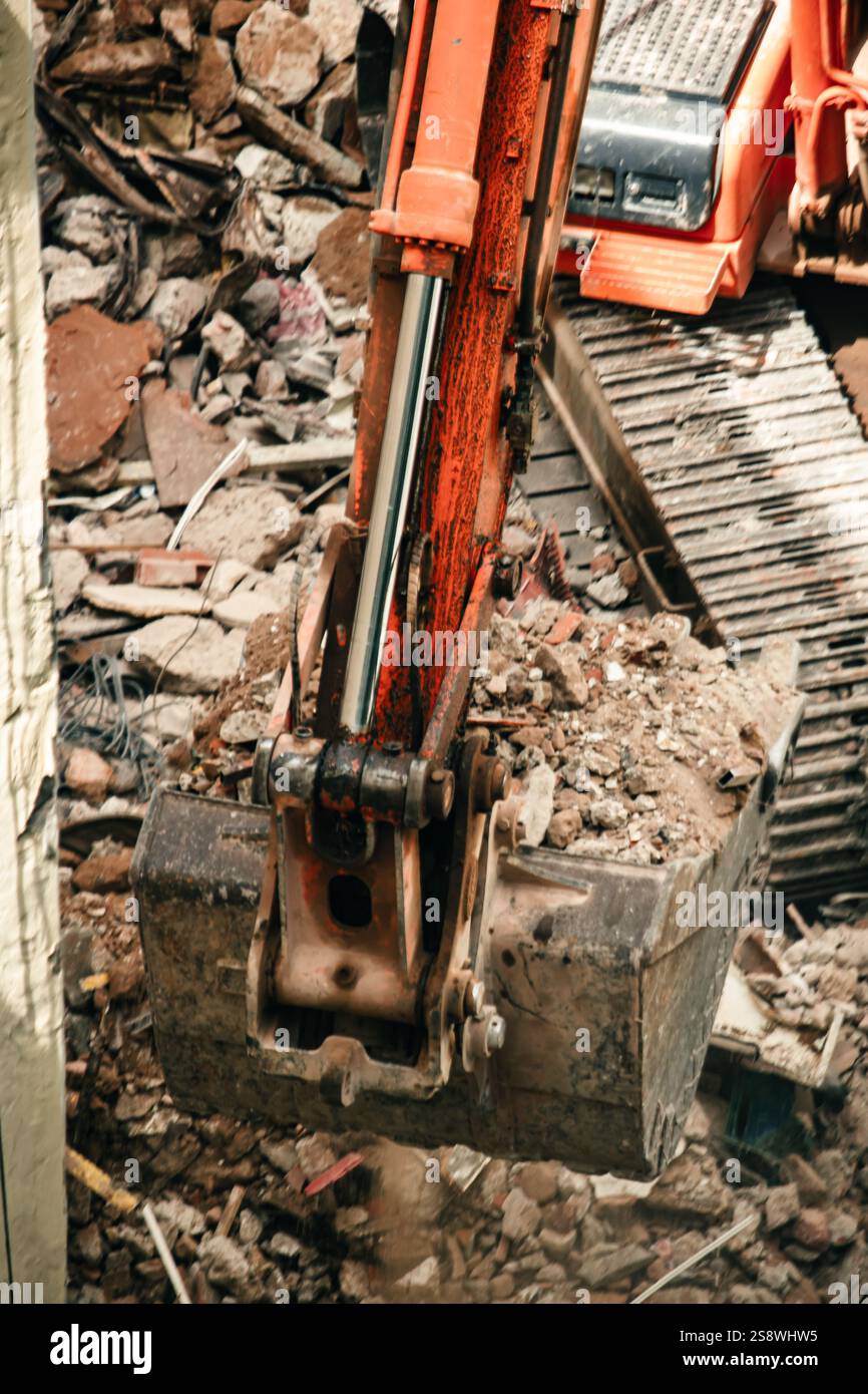 Excavator removing debris from a demolition site and dumping it Stock ...