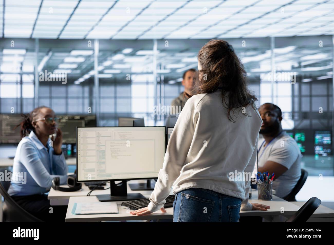 Manager supervising multiethnic team working in data center, raising ...