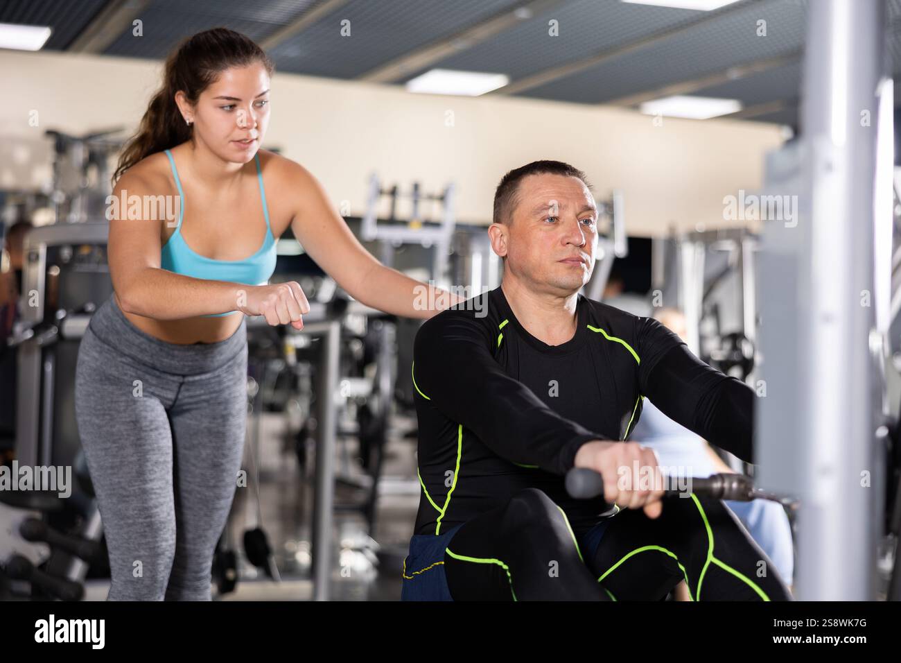 Female fitness trainer is engaged explains how to exercise on the ...