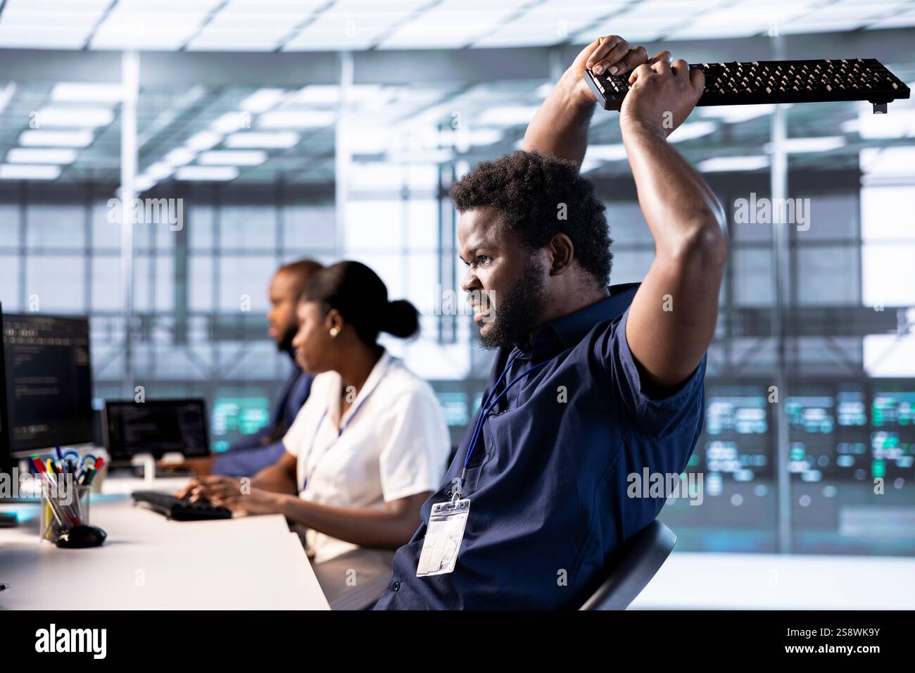 Mad software developer in data center smashing keyboard after identifying of errors using system ...