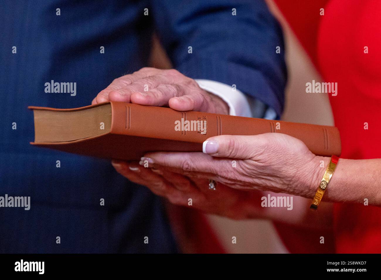 John Ratcliffe places his hand on a bible held by his wife Michele as ...