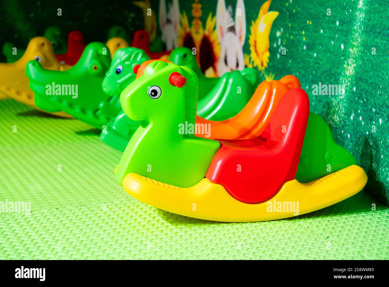 Bright plastic rocking horses in a cheerful indoor play area for kids ...