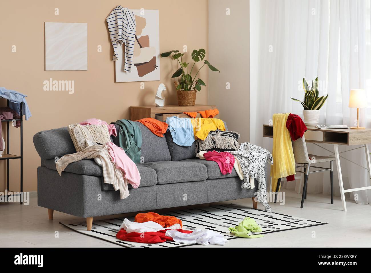 Interior of messy living room with grey sofa and piles of different ...