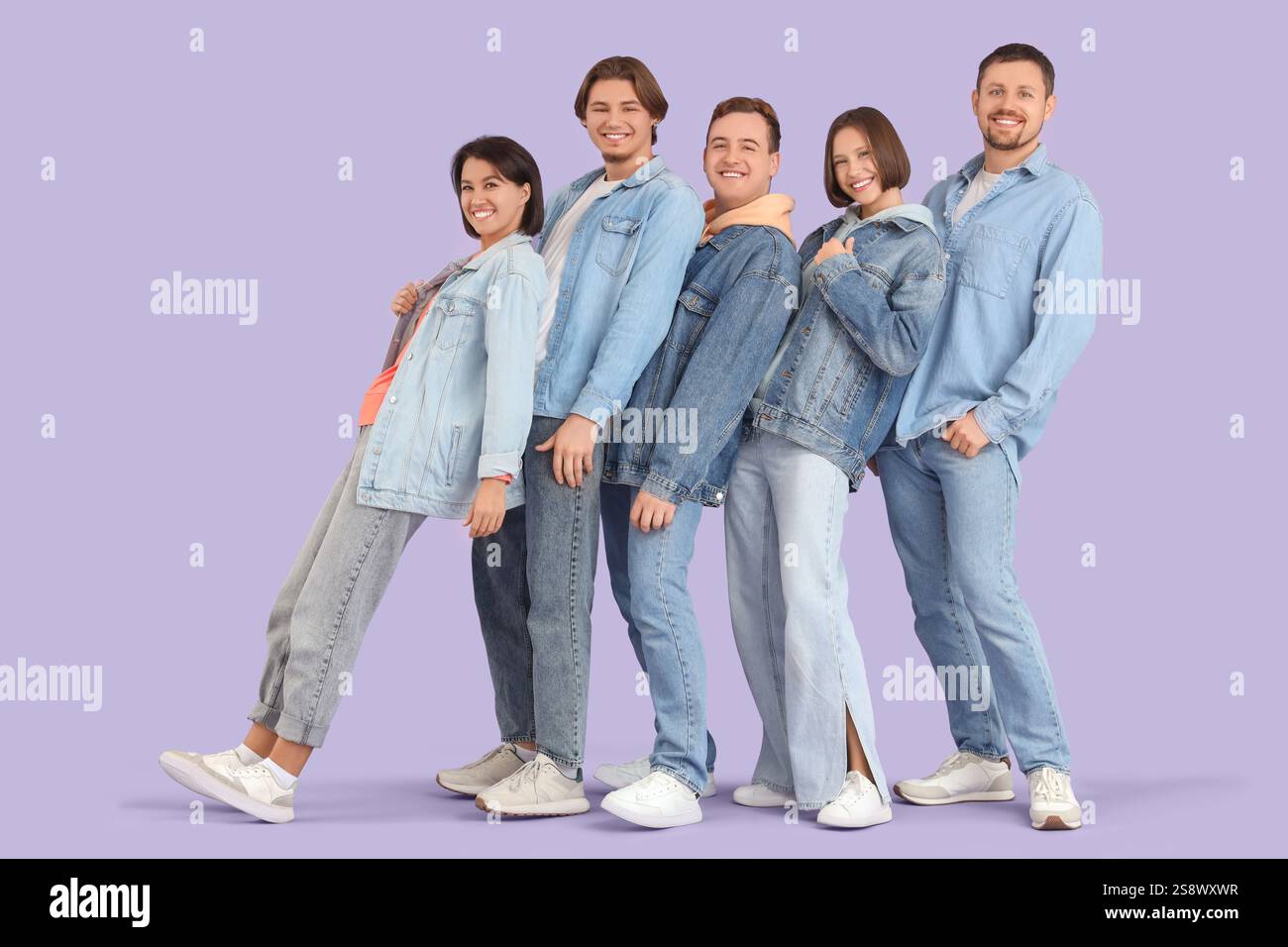 Group of young people in denim clothes on lilac background Stock Photo ...
