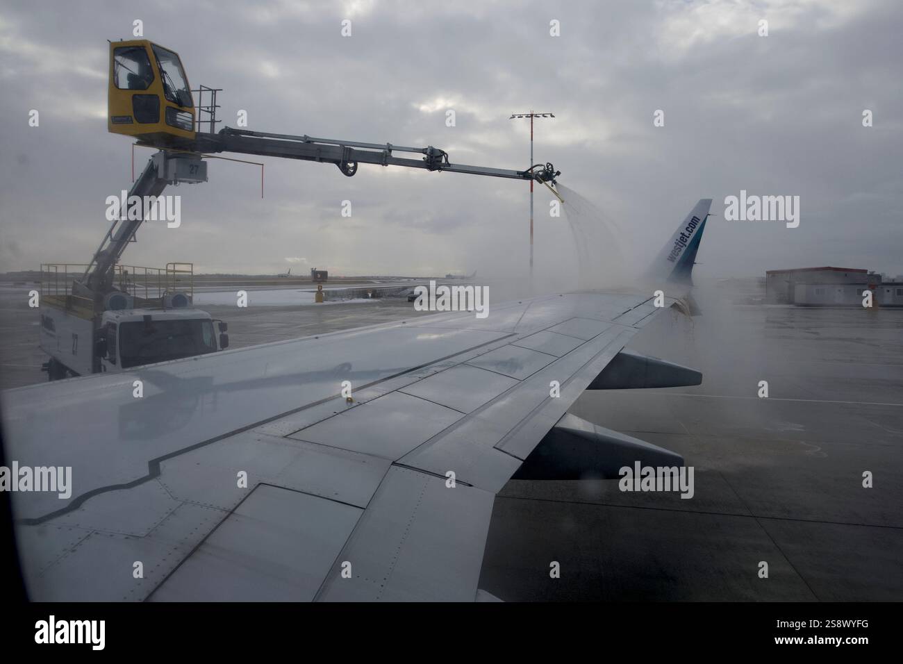 Westjet airplane being de-iced at Calgary Airport, Alberta, Canada ...