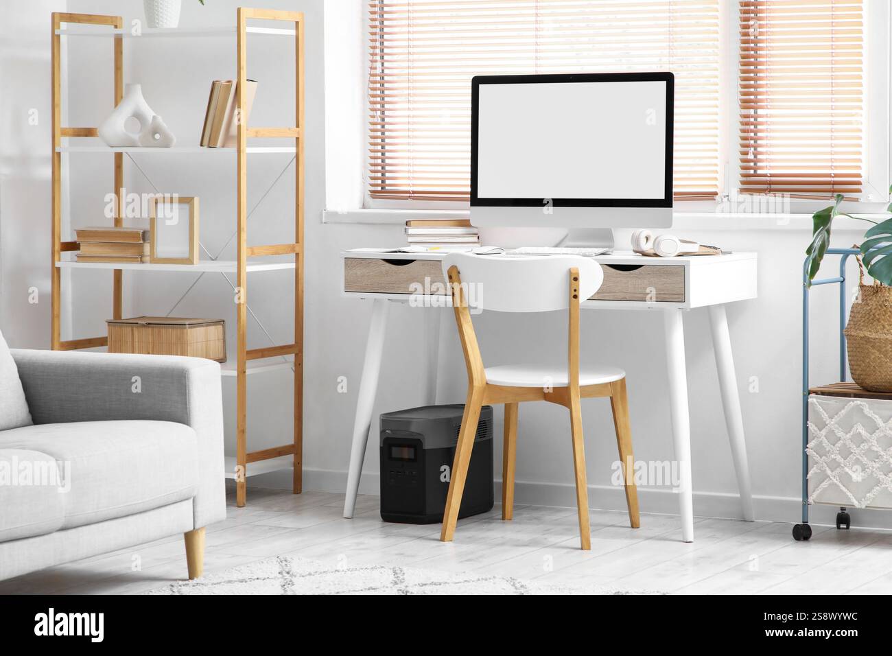 Workplace with blank computer monitor near window in light room ...