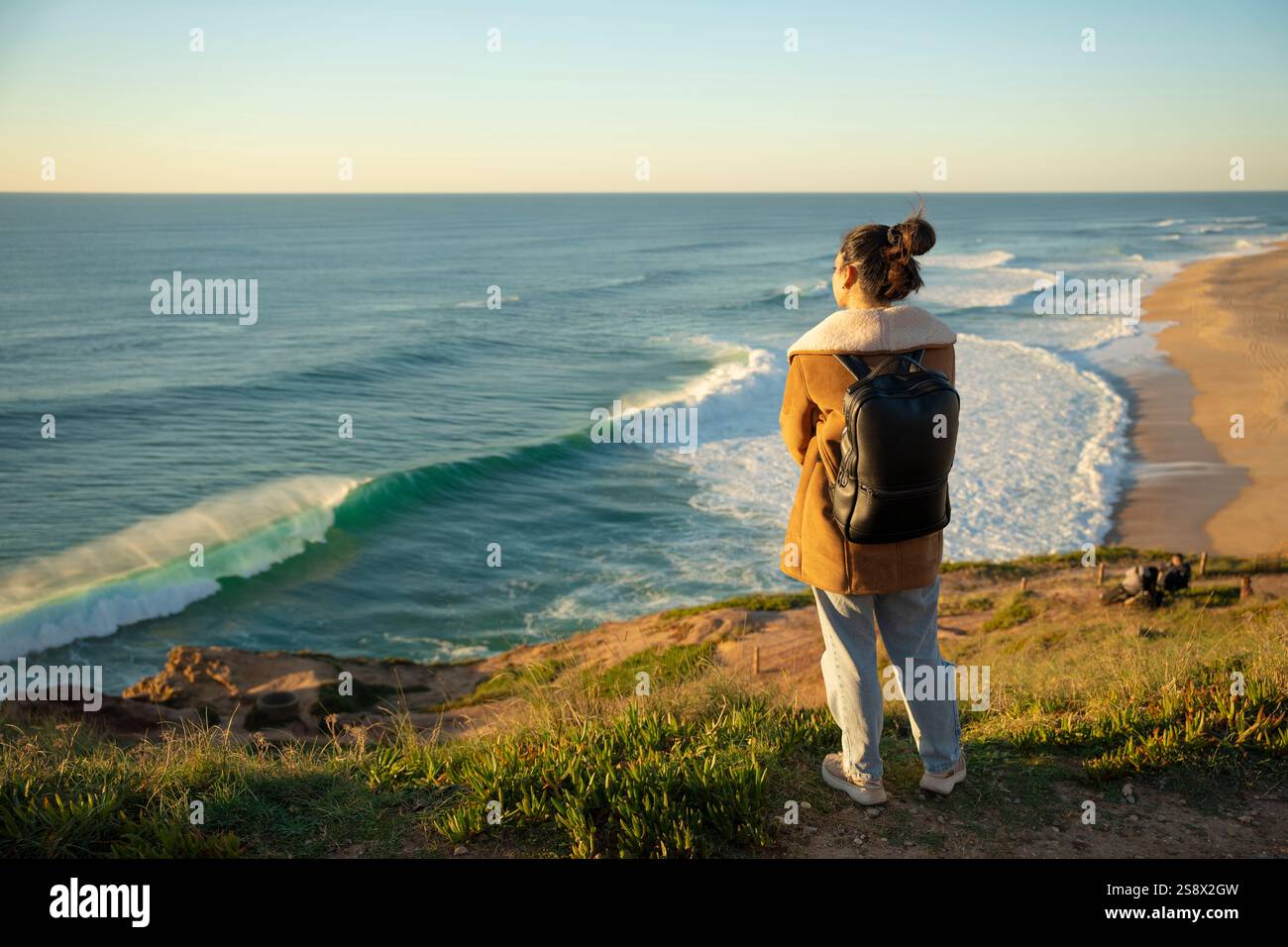 Backpacker on the beach in Nazaré, Portugal Stock Photo - Alamy