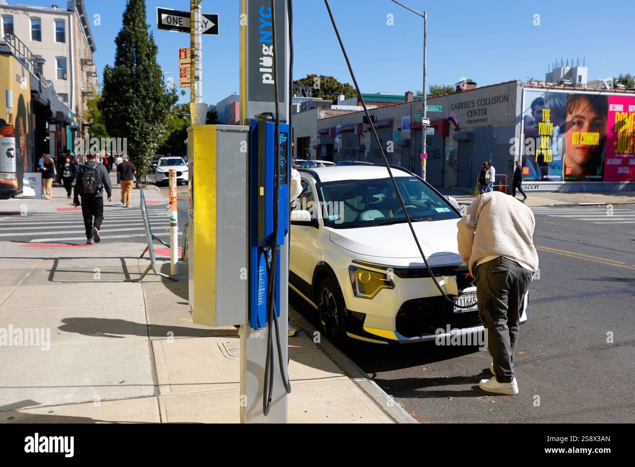 A person plugs their electric vehicle into a FLO EV charger at a ...