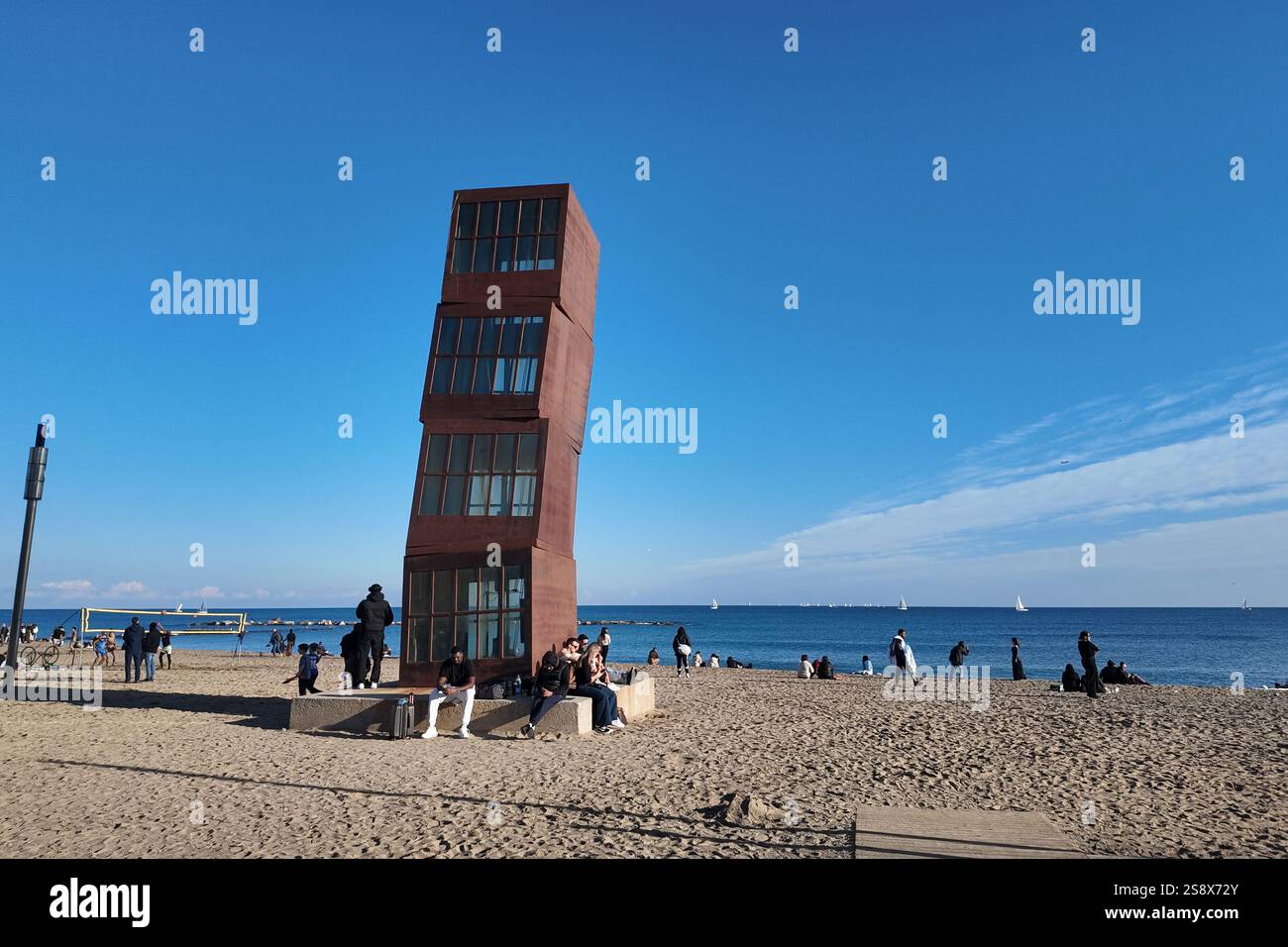 outdoor art work of a stack of brown blocks on a beach in barcelona ...