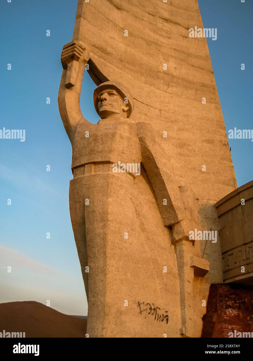 A statue of a man holding a large flag and gun. The statue is of a man ...