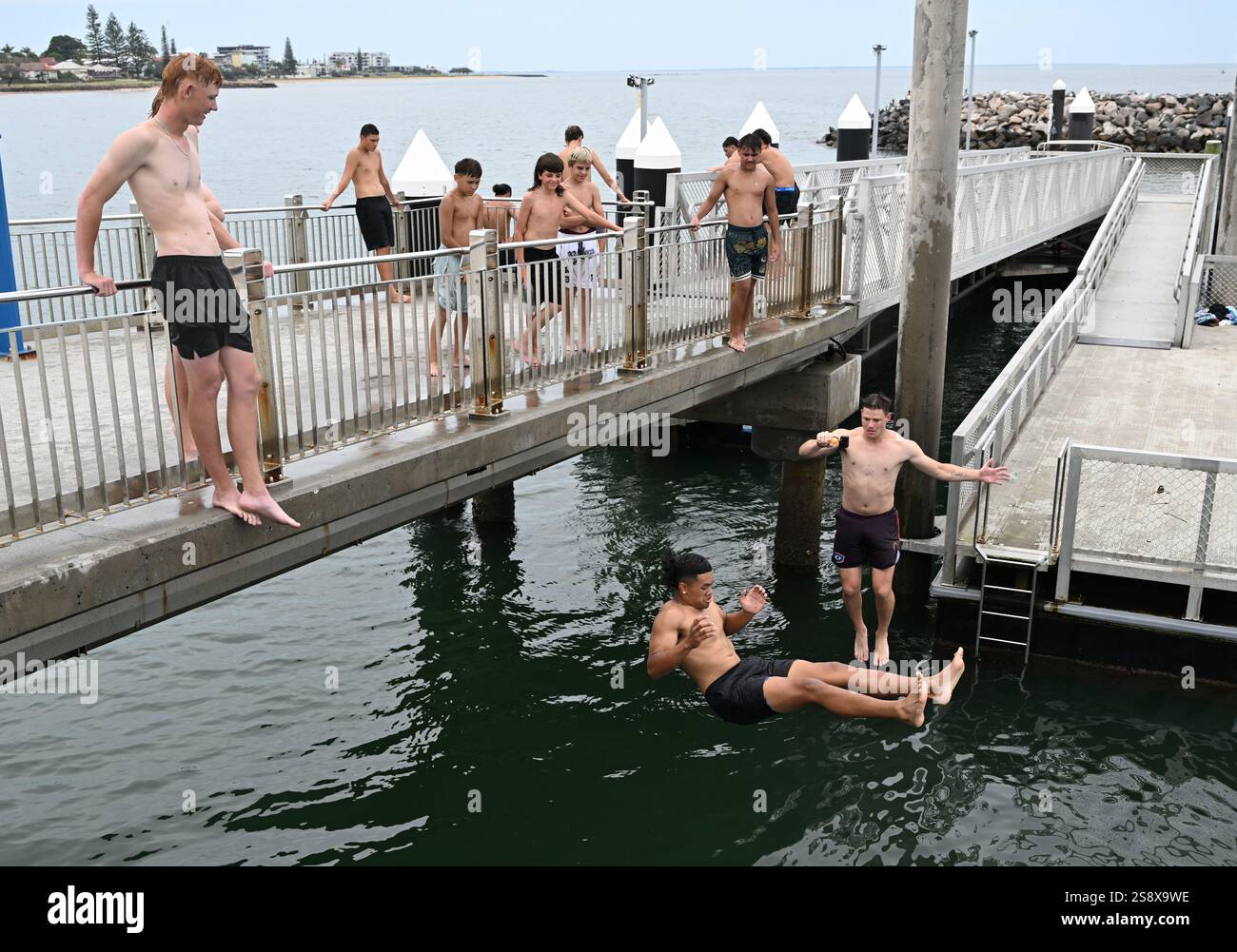 People are seen cooling off from the Redcliffe Jetty during high ...