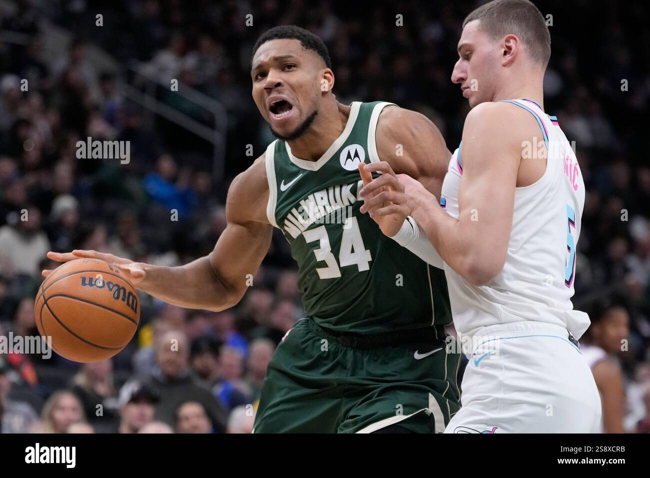 Milwaukee Bucks' Giannis Antetokounmpo is fouled by Miami Heat's Nikola ...