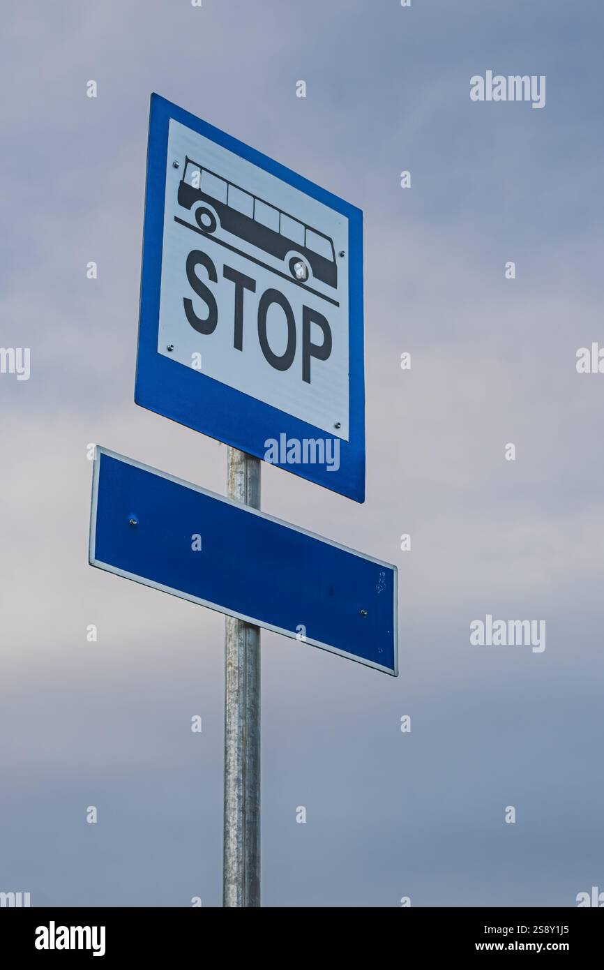 A vertical shot of a blue bus stop sign with a blank destination sign ...