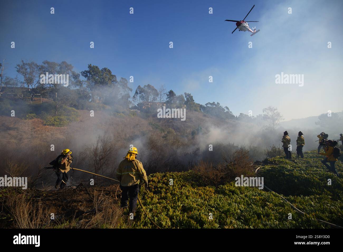 Firefighters battle with the fire at the fire scene while an aircraft ...