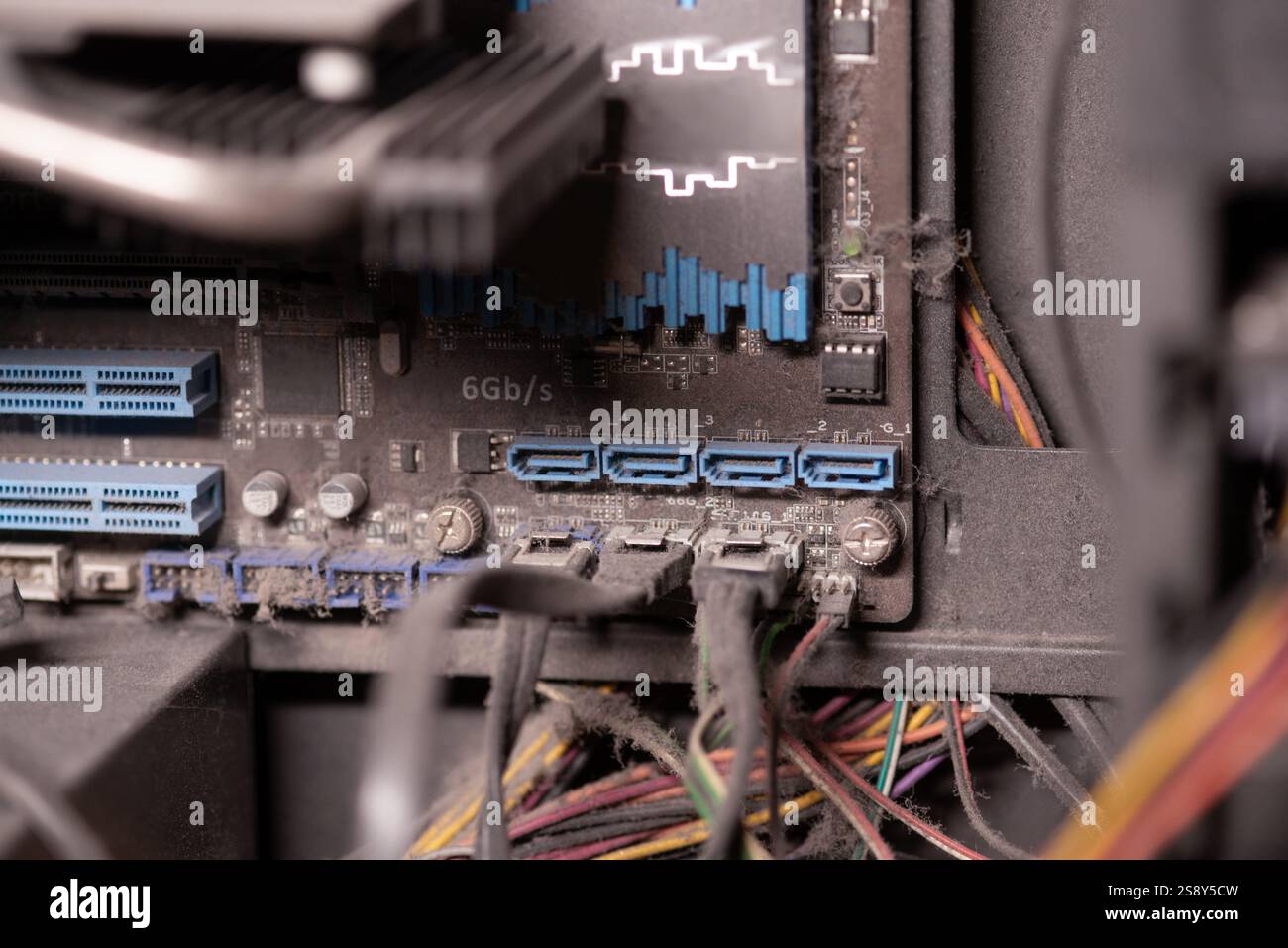 Close-up of a dusty computer motherboard with visible SATA ports and ...