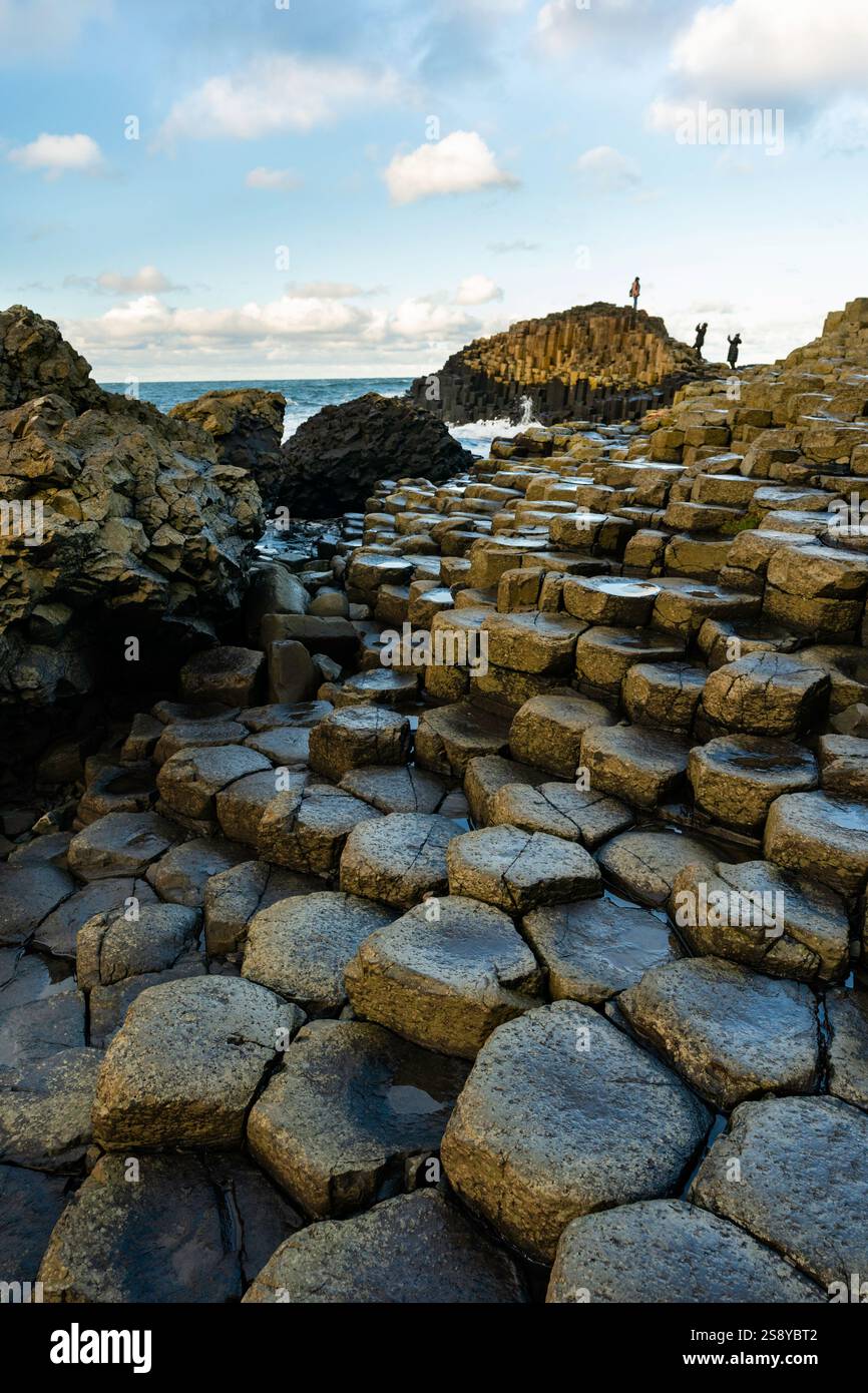 Tourists climb the basalt rocks at the GIant's Causeway, Ireland ...
