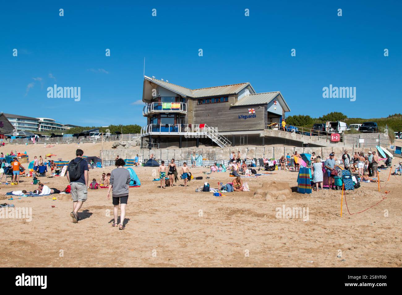 The RNLI lifeguard building on Fistral Beach on a busy, sunny day ...