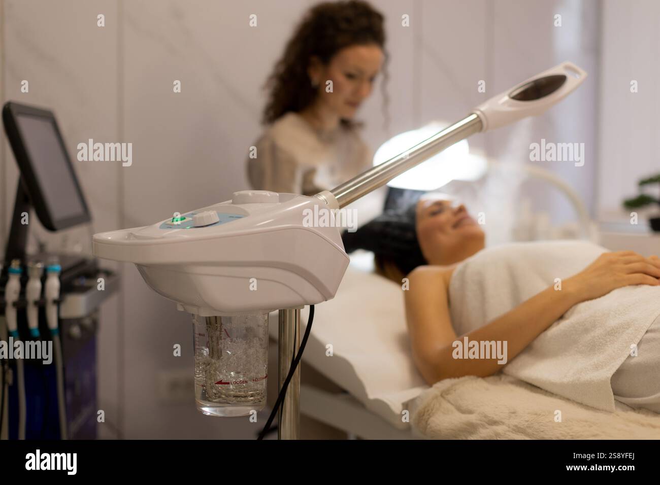 A tranquil spa setting features a woman enjoying a facial treatment ...