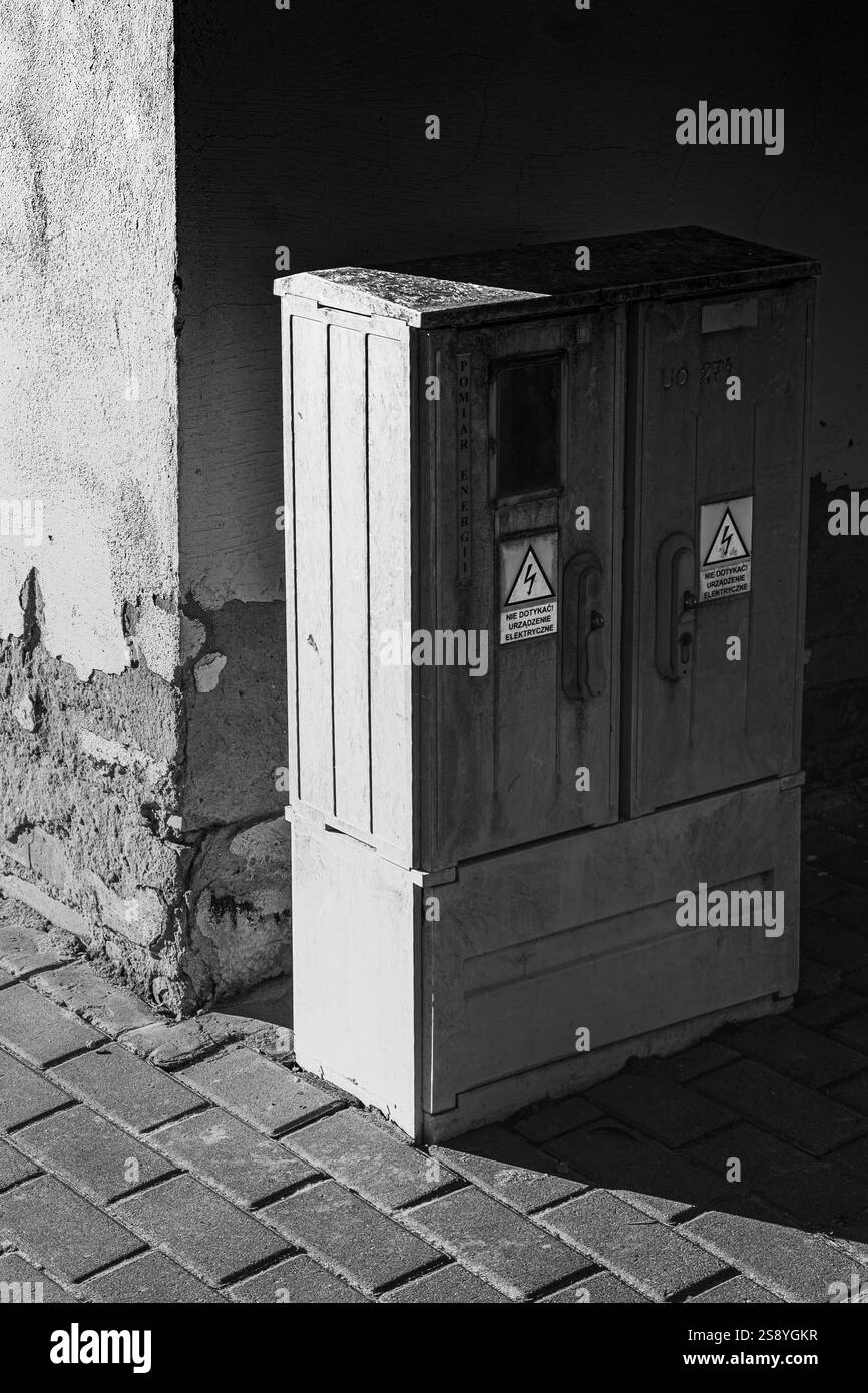 Utility box stands against a textured wall on a cobblestone street in ...