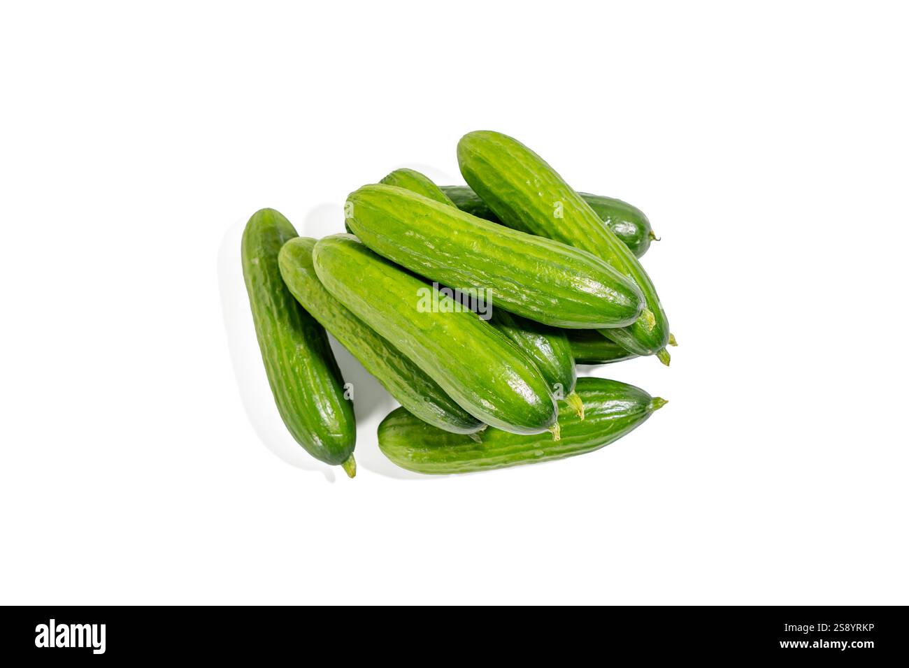 A bunch of cucumbers is folded at each other. They are green and have ...