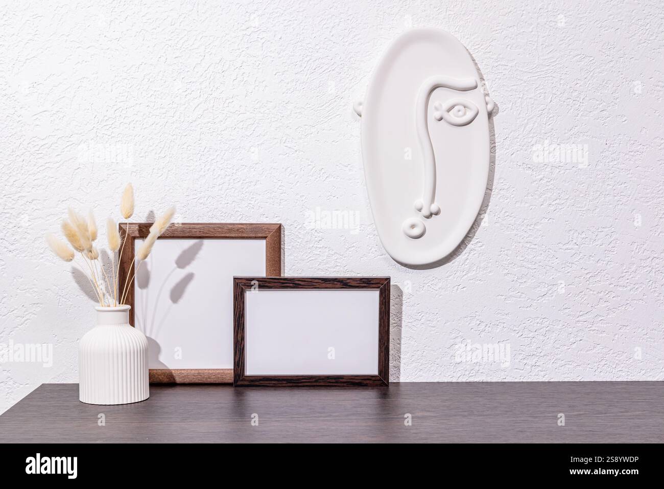 photo frames, a white ceramic vase with lagurus, stylish plaster panel ...