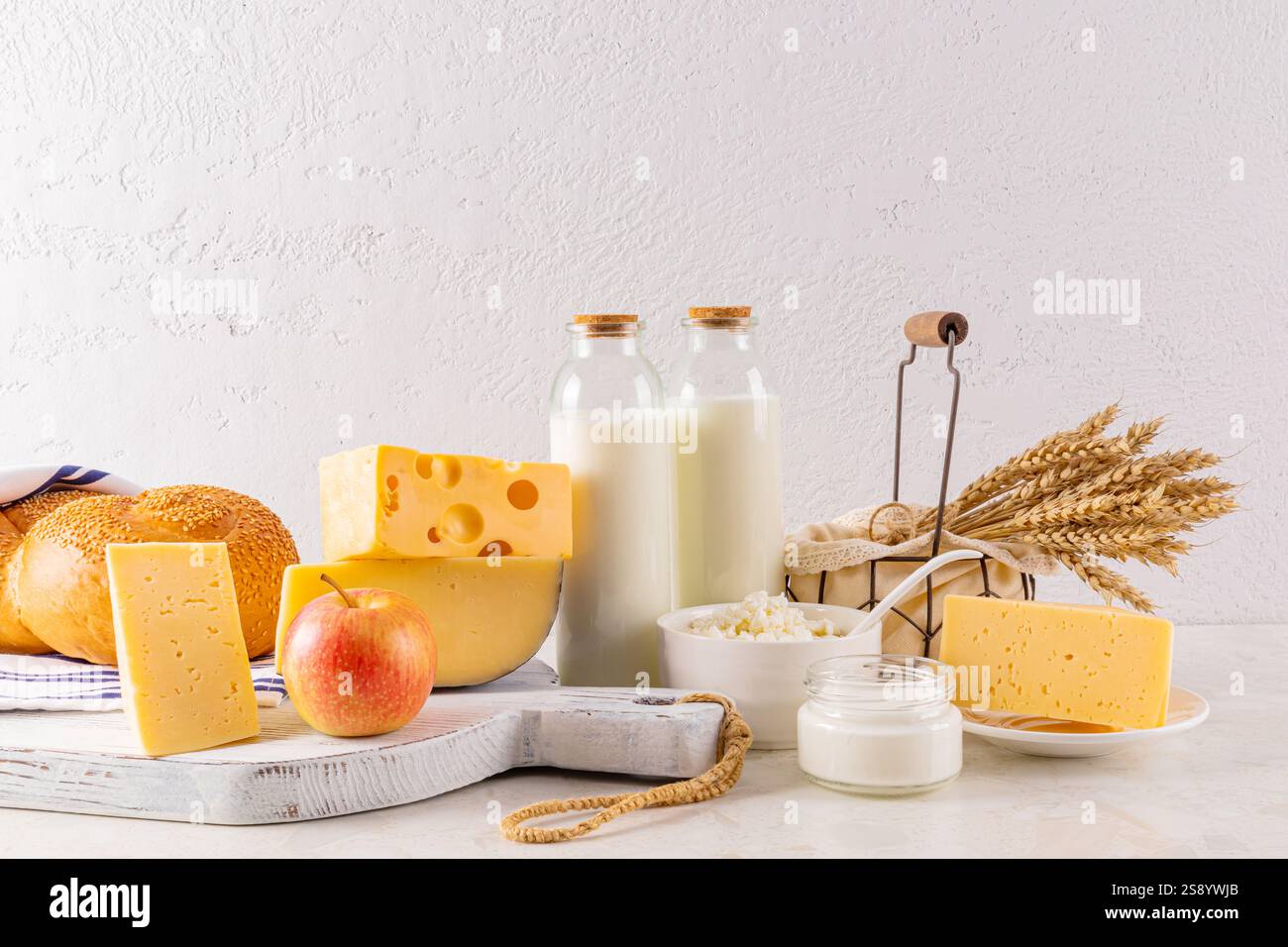 Many varieties of cheese on a board, bottles of milk, cottage cheese ...