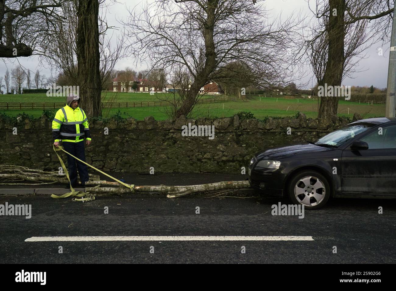 A man attends to a fallen tree on Malahide Road in Dublin. Residents ...