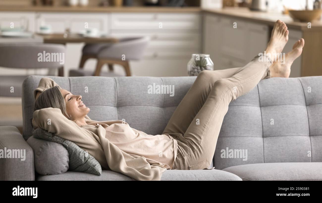 Smiling mid aged woman relax on couch with closed eyes Stock Photo - Alamy