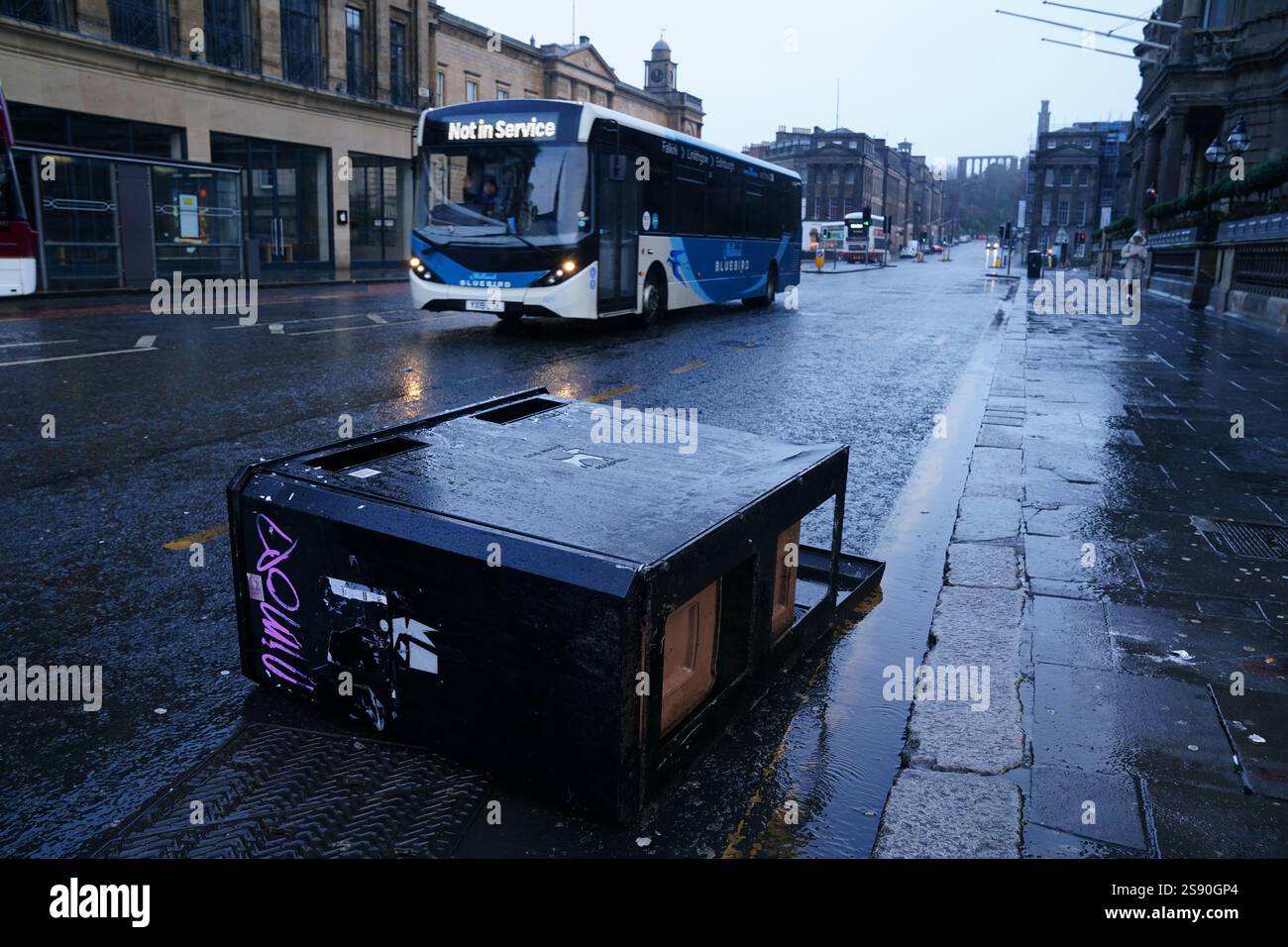 A bus drives around bins blown over by the winds from Storm Eowyn on ...