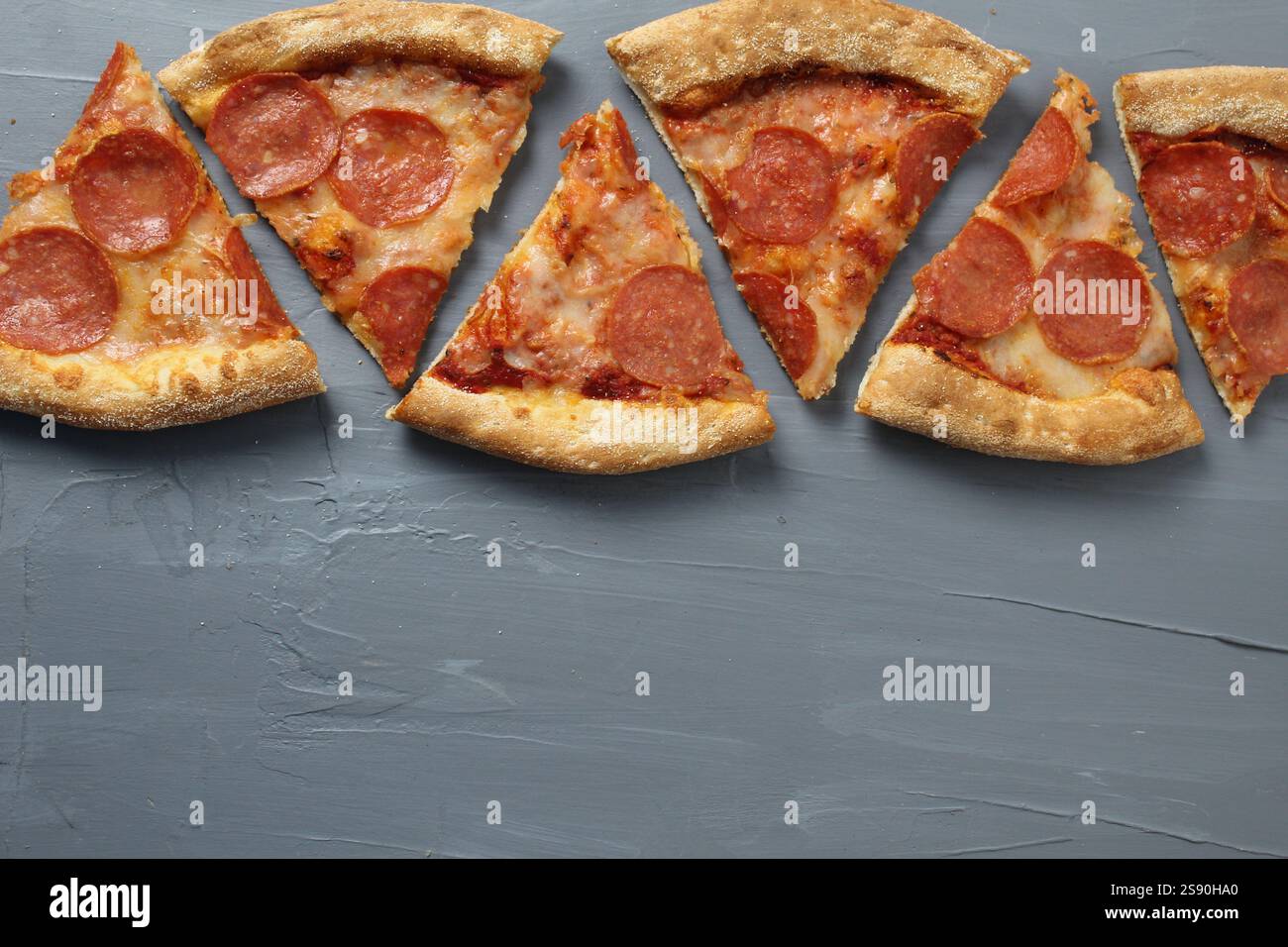 Edging of slices of pizza on a gray background with space for copyspace ...