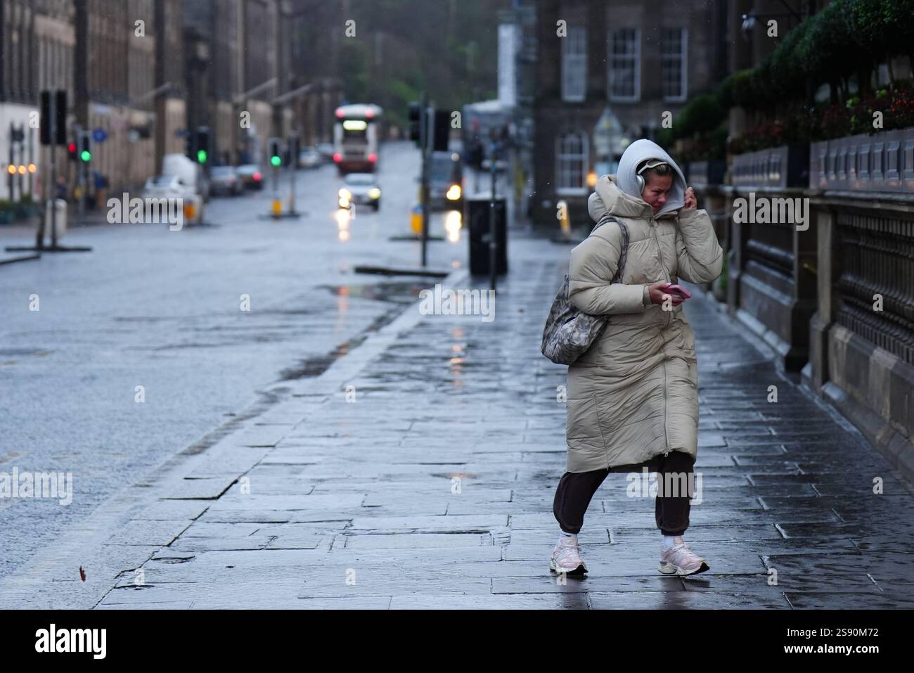 A woman shields herself from the wind during Storm Eowyn on Princes ...