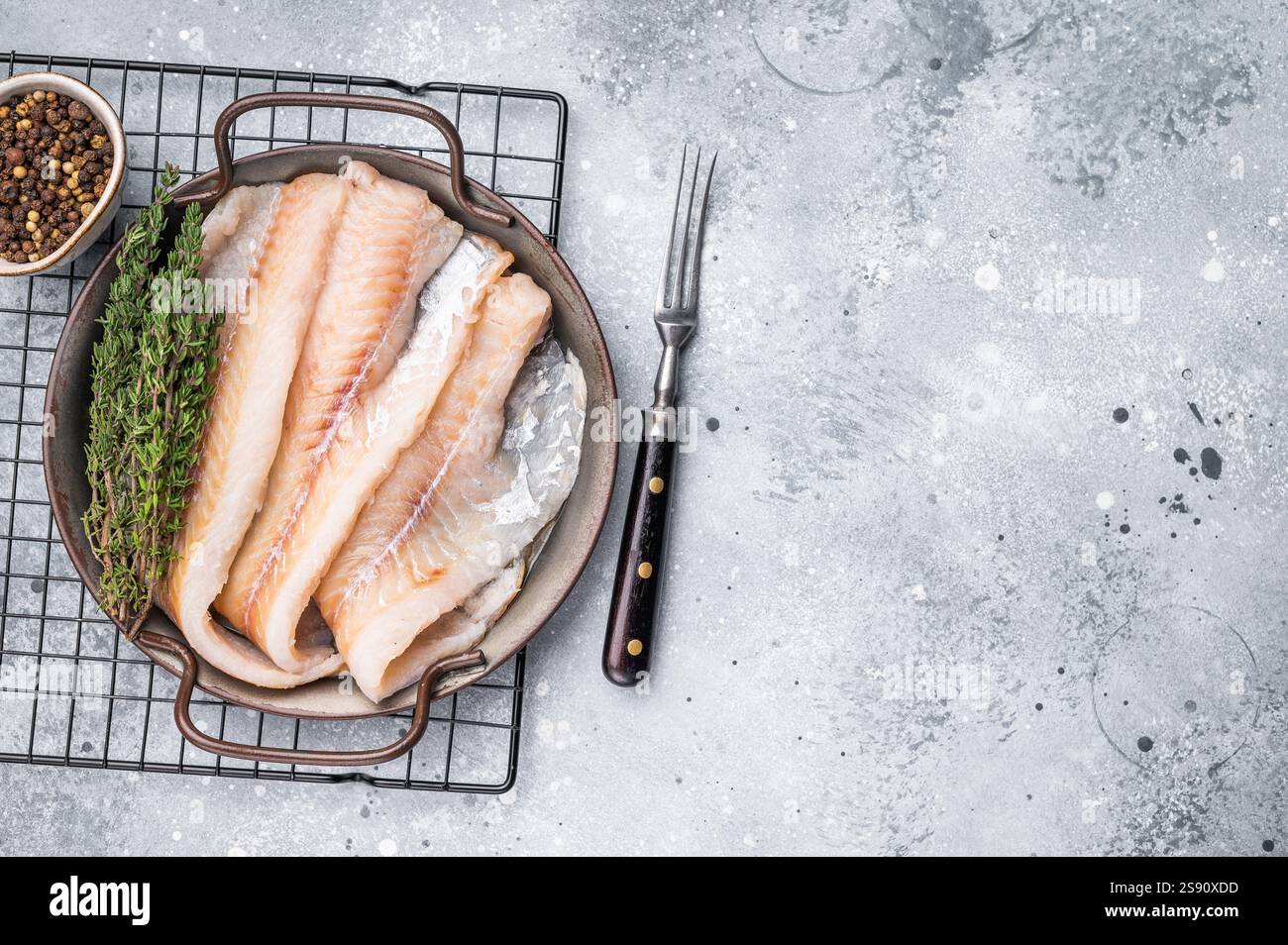 Raw Hake fish fillet in steel tray with herbs. grey background. top ...