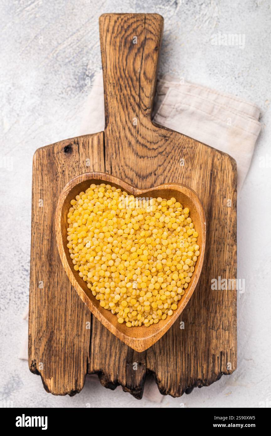 Dry Ptitim pasta, Israeli couscous in wooden bowl. white background ...