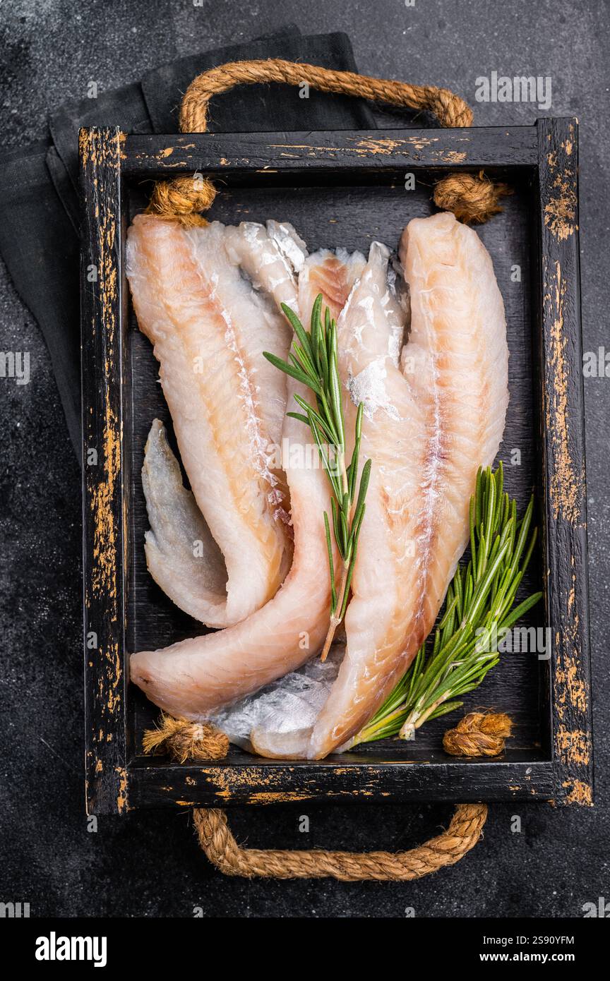 Ready for cooking Raw Hake fish fillets in a wooden tray with herbs ...