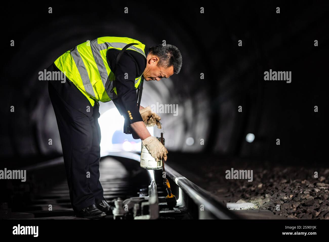 (250124) -- DALI, Jan. 24, 2025 (Xinhua) -- Li Yanlin applies lubricant on the rails near the ...
